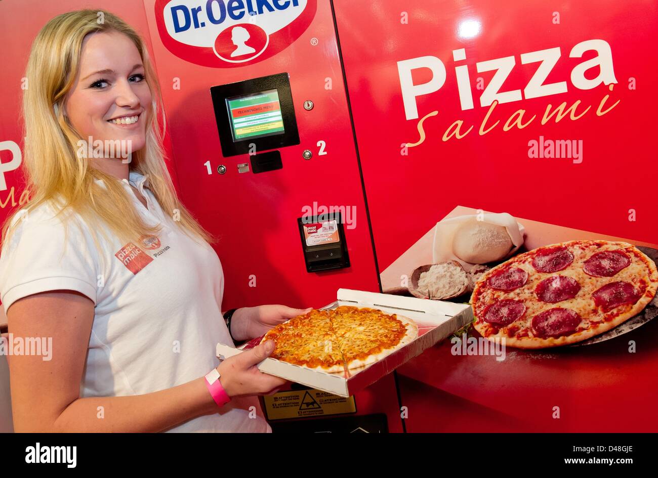 A hostess presents a pizza prepared by pizza machine by company ...