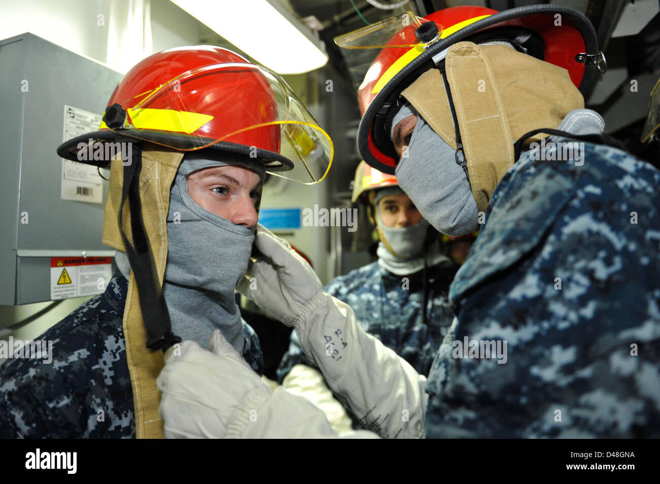 Sailors aboard a U.S. Navy ship dress out in firefighting gear for ...