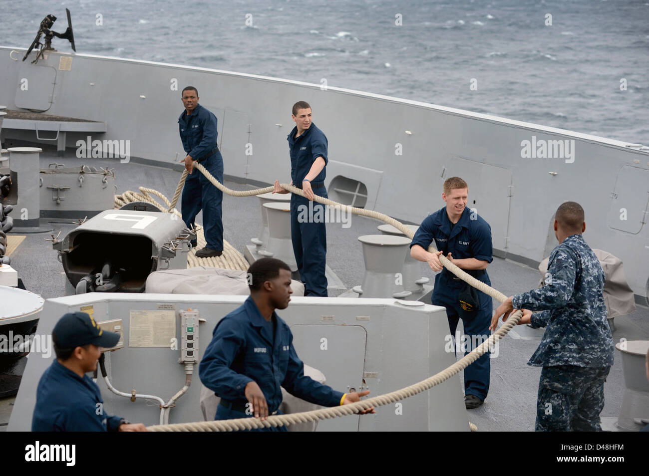 Sailors handle a line aboard USS Mesa Verde Stock Photo - Alamy