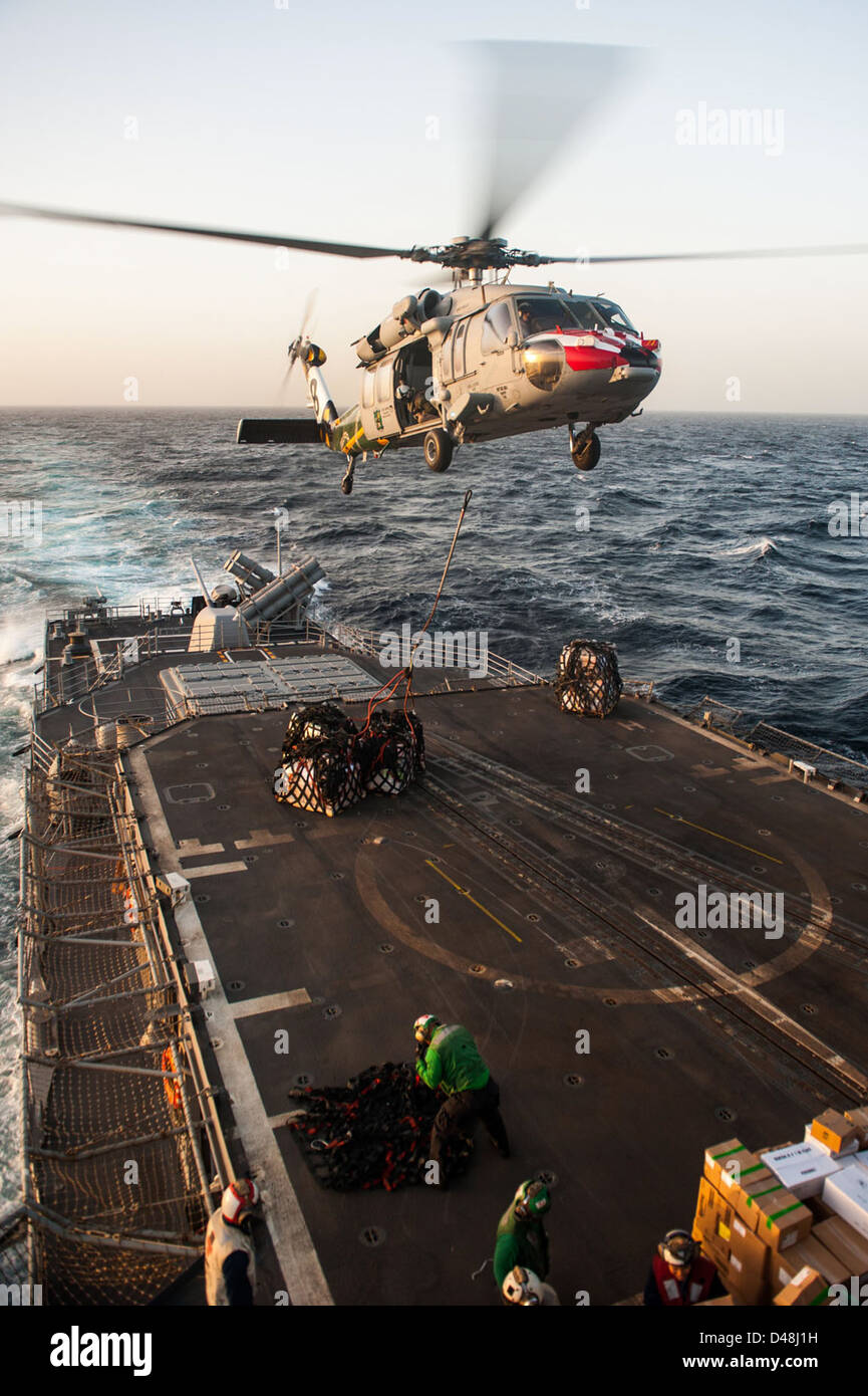 An MH-60S Seahawk helicopter delivers cargo to the USS Mobile Bay in ...