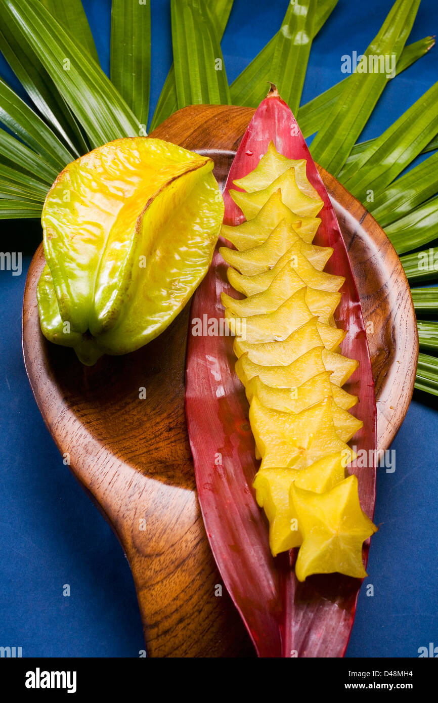 Studio Shot Of Starfruit, Whole And Cut Into Slices, With Flowers Stock ...