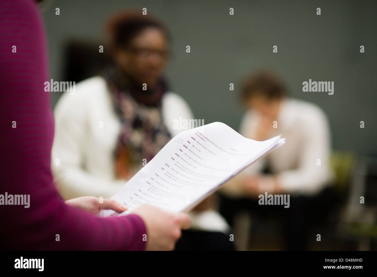 Three Actors in a rehearsal, holding their scripts, reading lines of ...