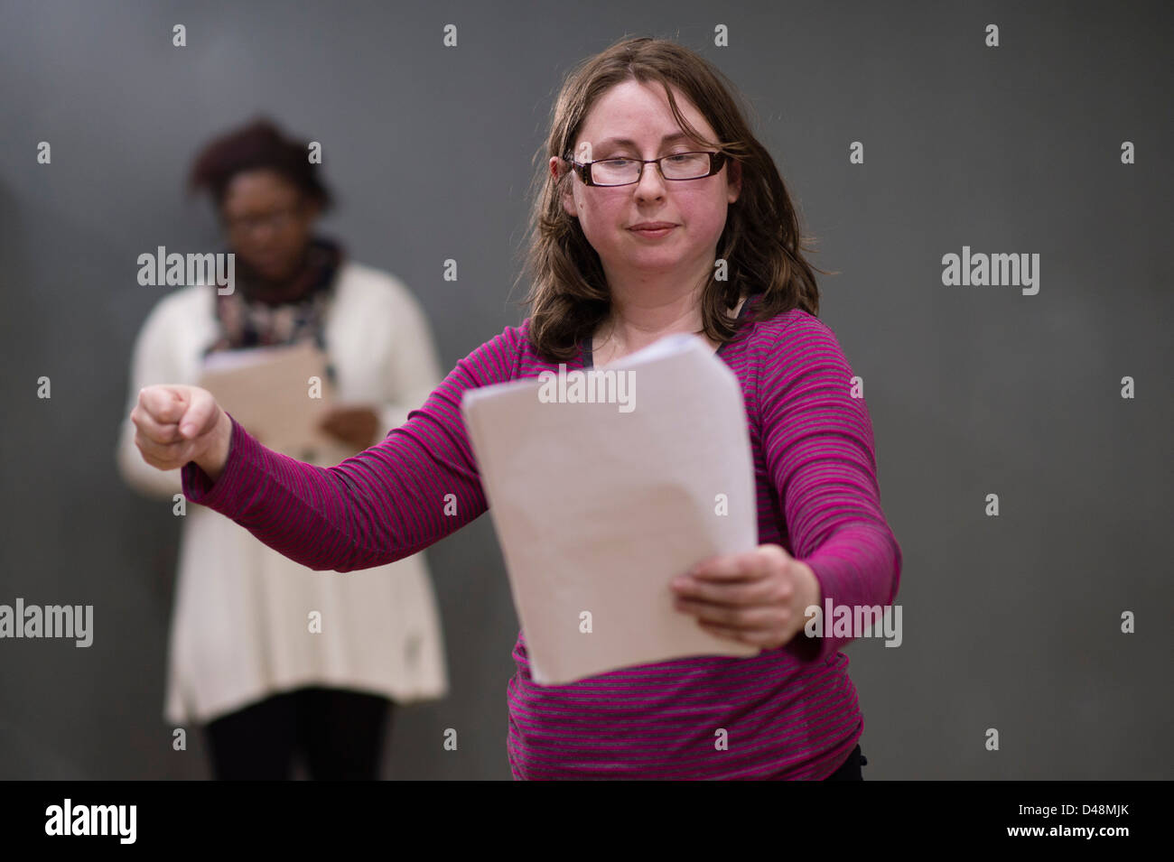 Two Actors in a rehearsal, holding their scripts, reading lines of ...