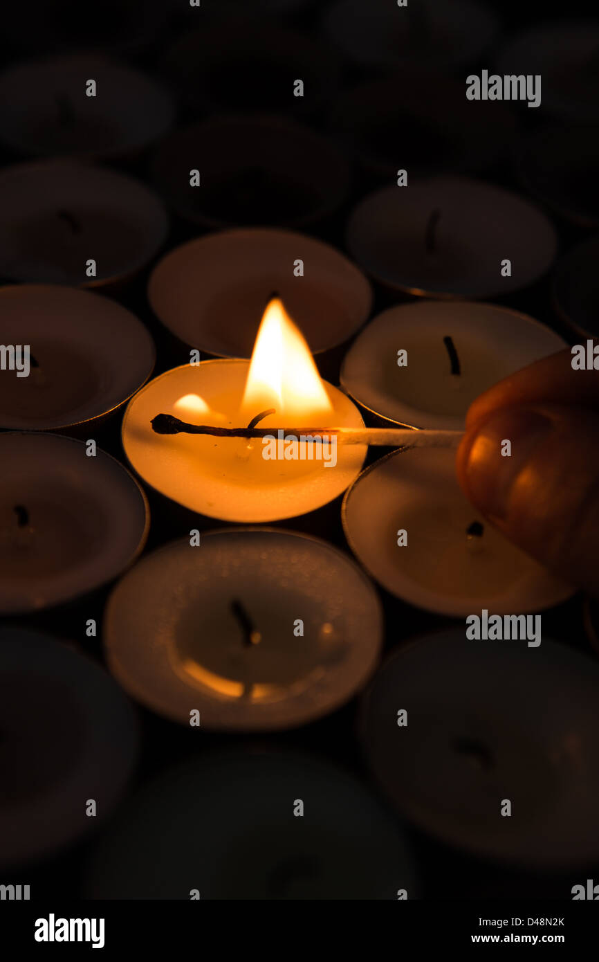Hand lighting candle with match Stock Photo - Alamy