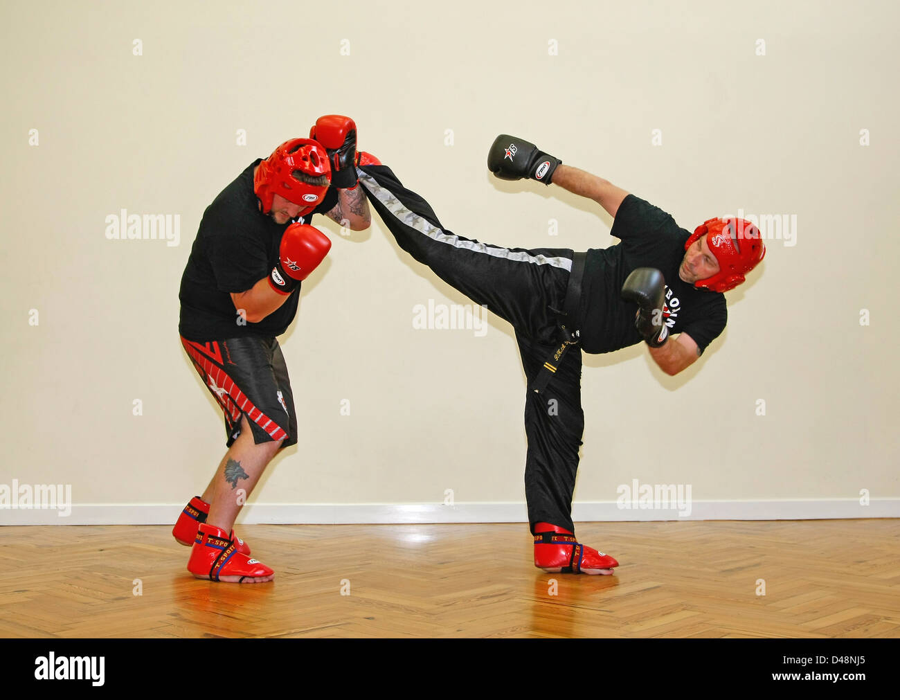 One man posed kicking at another man's head during a martial arts class ...
