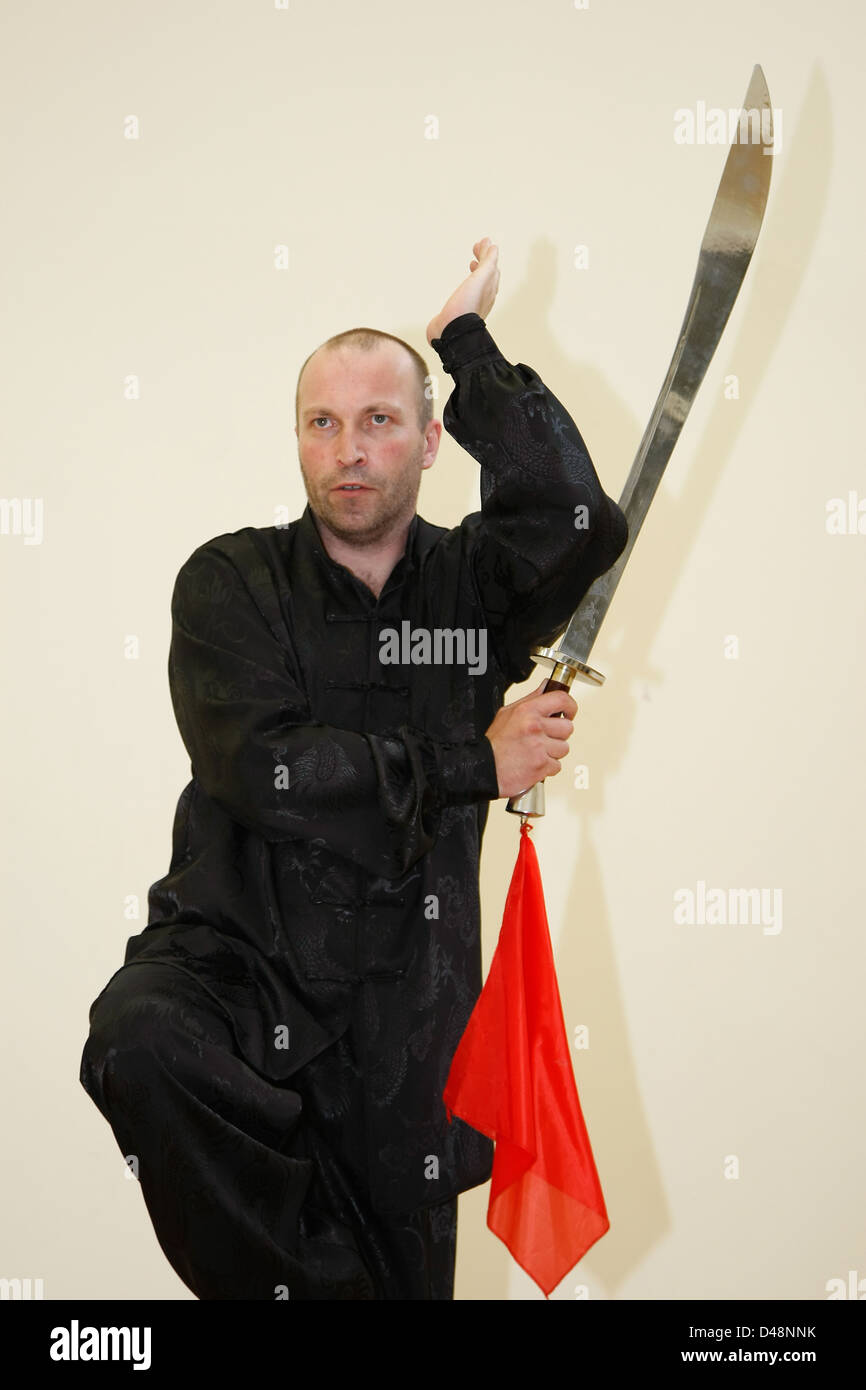Man posing in a martial arts stance with a ceremonial sword Stock Photo ...