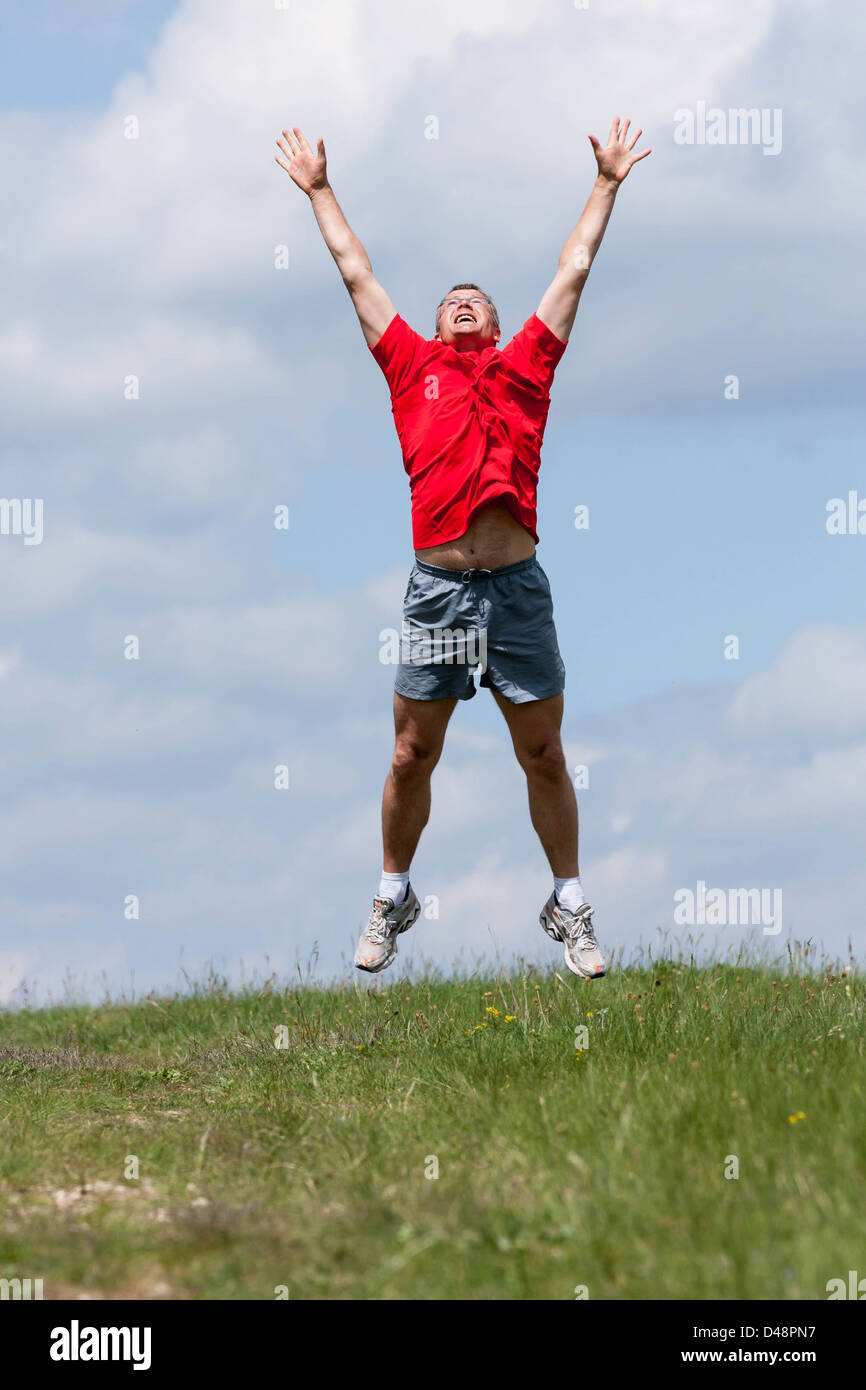 Funny young man high jumping in the field Stock Photo - Alamy