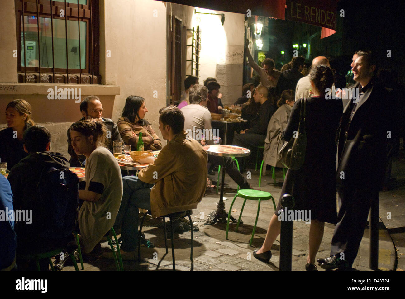 People sitting outside bars and cafes in Montmartre Paris in the late ...