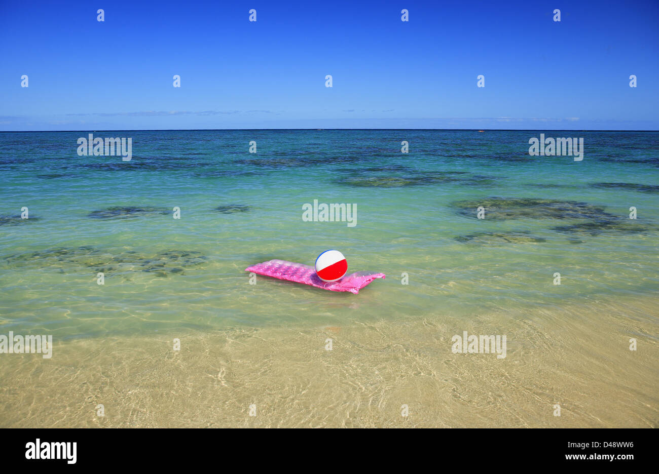 Pink Inflated Raft And Beachball On Clear Ocean Water Stock Photo - Alamy