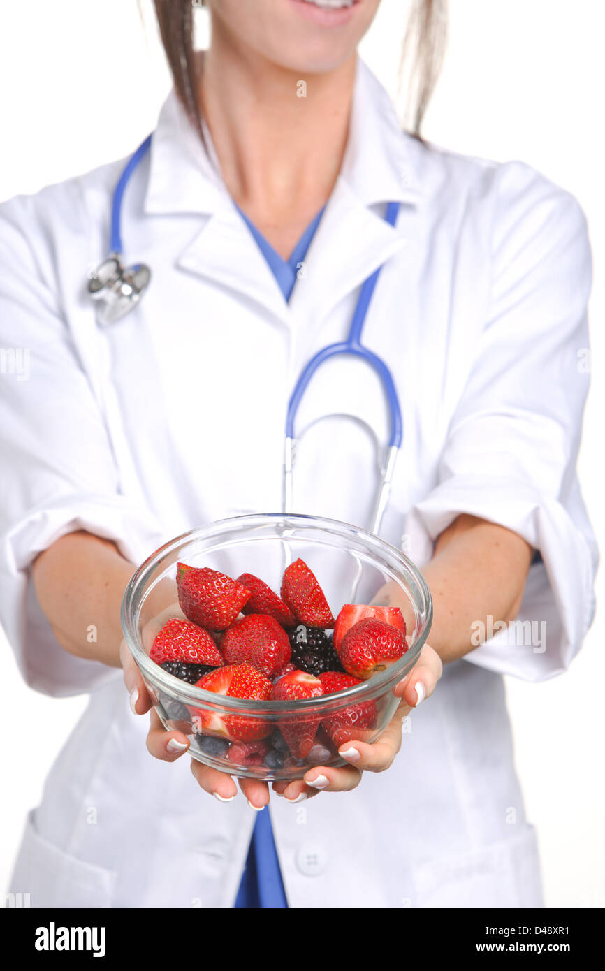 Woman doctor holding fresh fruit Stock Photo - Alamy