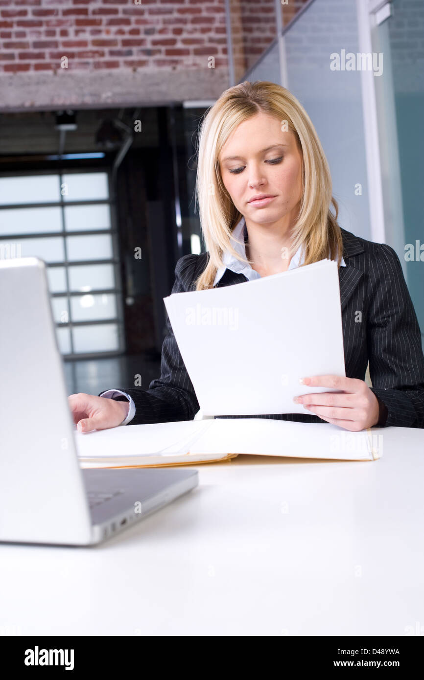 Business woman reading documents in modern office Stock Photo - Alamy