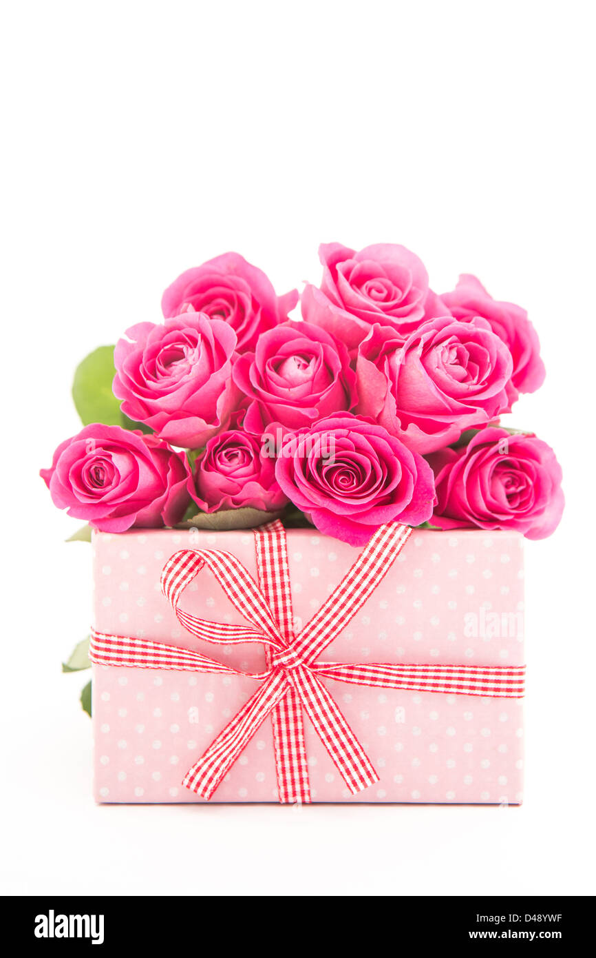Bouquet of beautiful pink roses next to a pink gift on white background ...