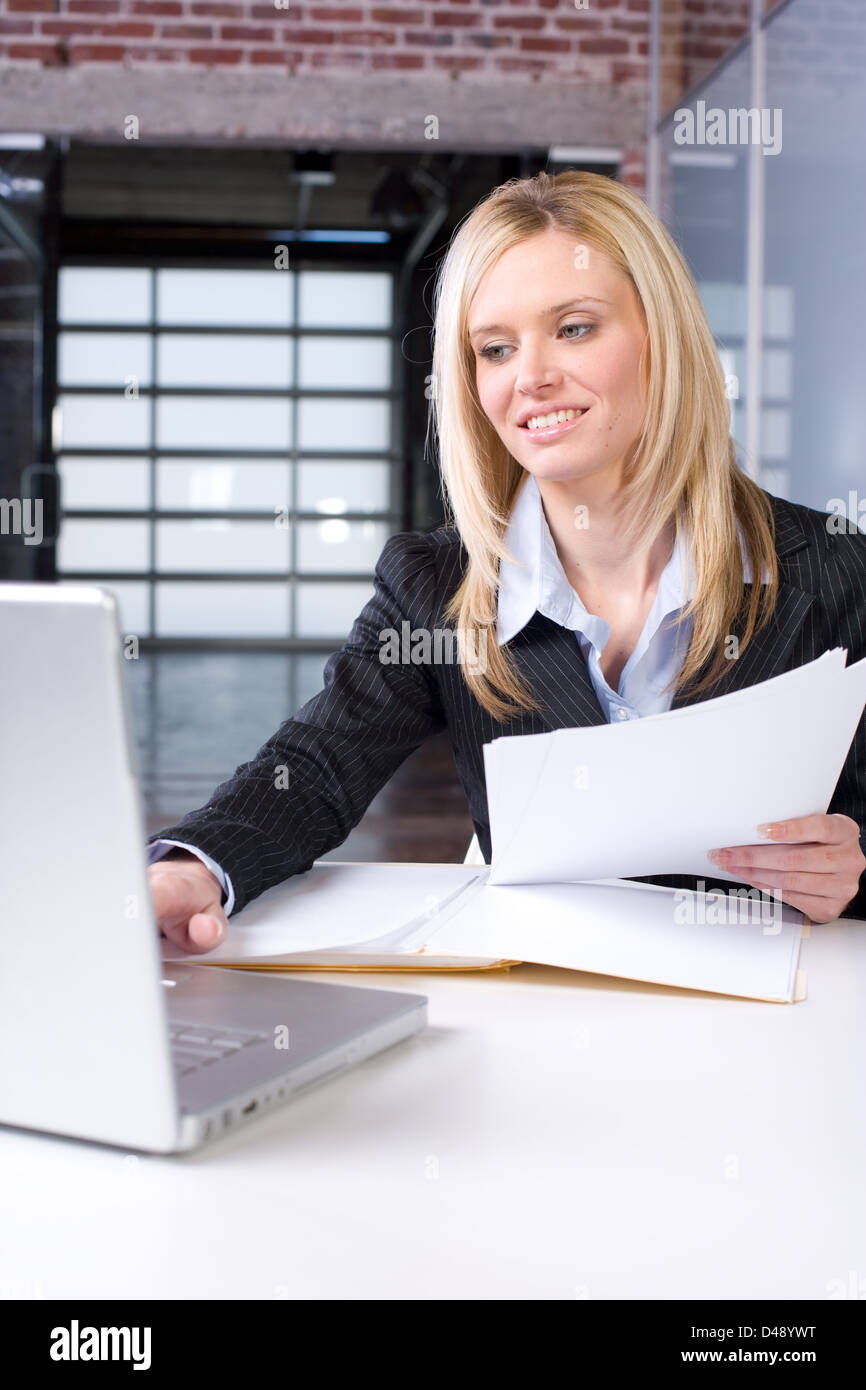 Business woman reading documents in modern office Stock Photo - Alamy