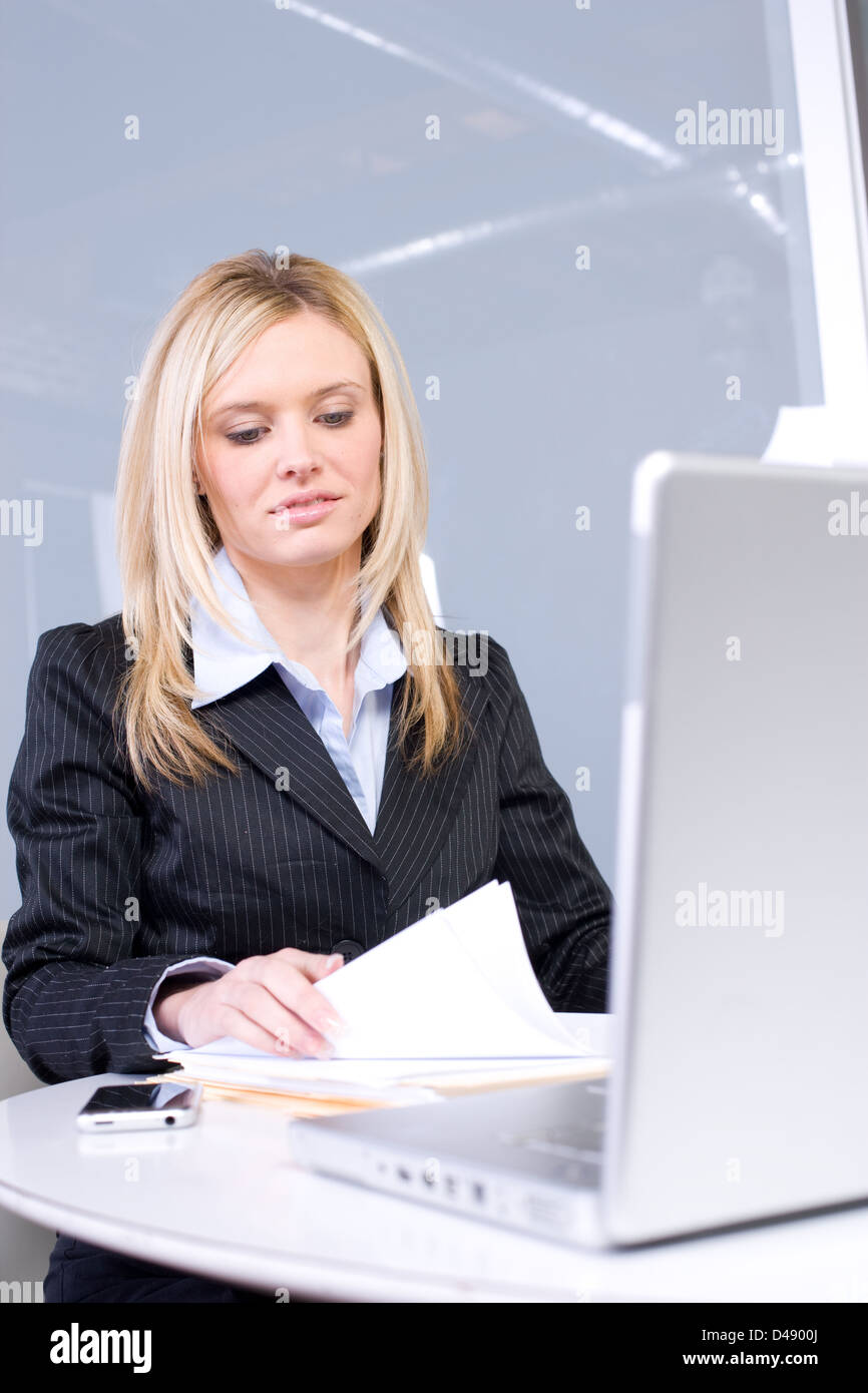 Business woman reading documents in modern office Stock Photo - Alamy