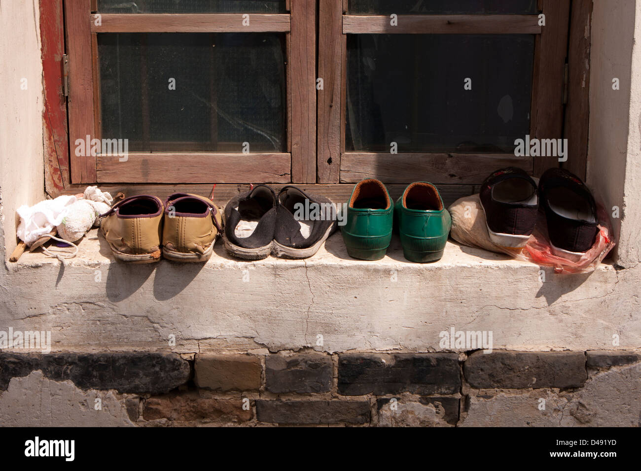 Shoes lines up on a window sill Stock Photo - Alamy