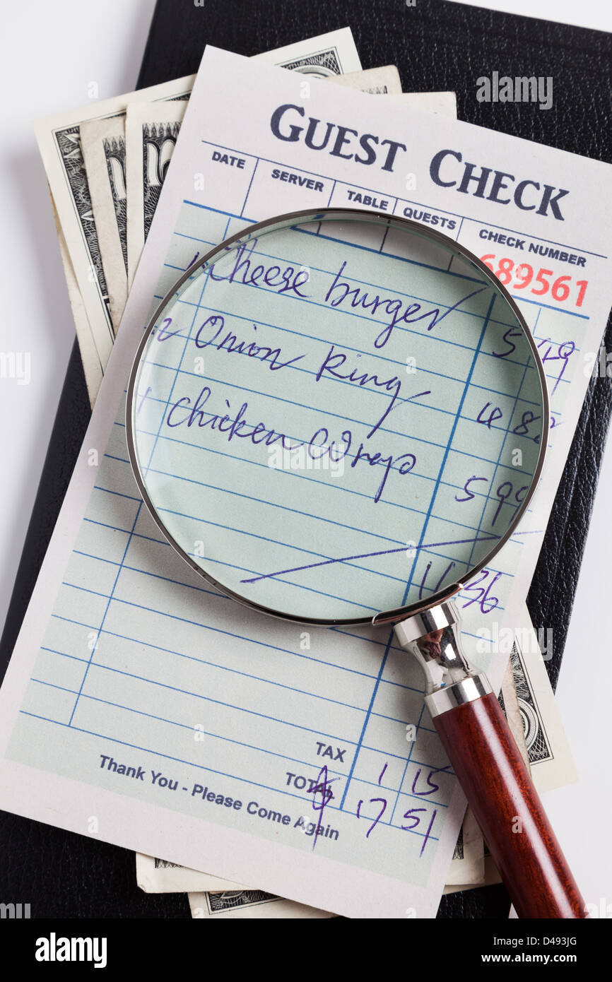 Guest Check and magnifying glass, concept of restaurant expense fraud ...