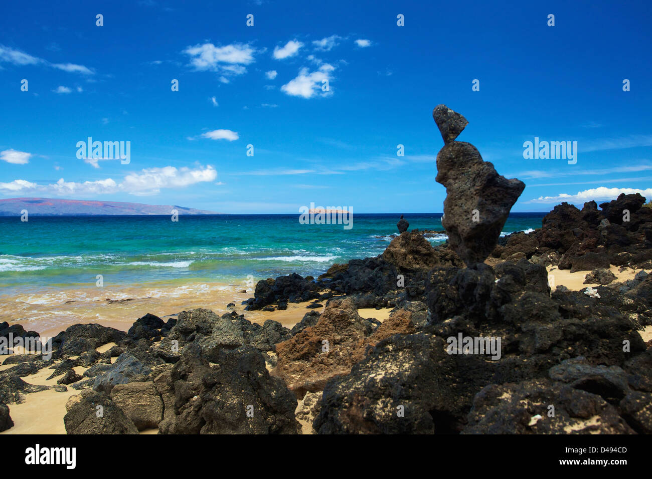 Rugged Black Rocks Sitting On The Sand Along The Coast Of An Hawaiian ...
