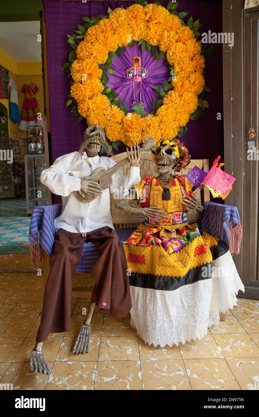 Male and female wood-carved skeletons at entrance to Mujeres Artesanas ...