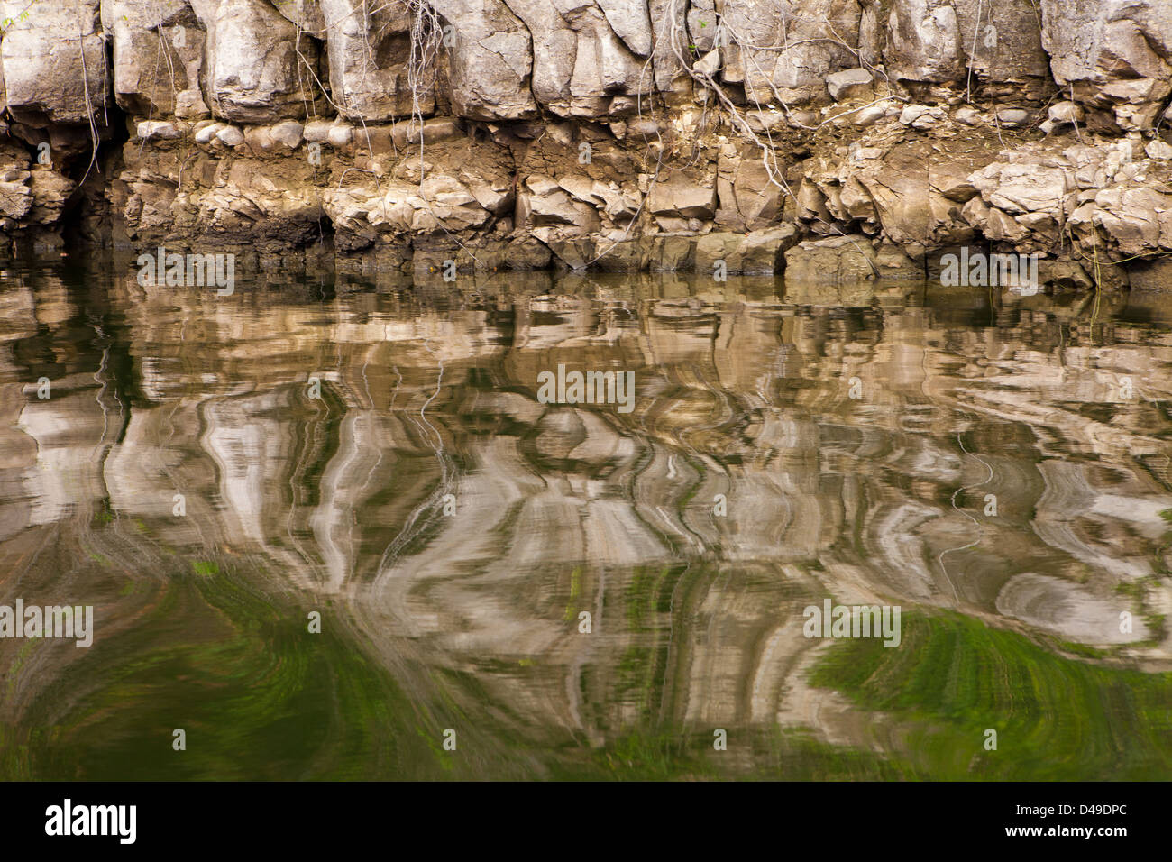 Rocks at the lakeshore of Lago Bayano (lake) with abstract reflections ...