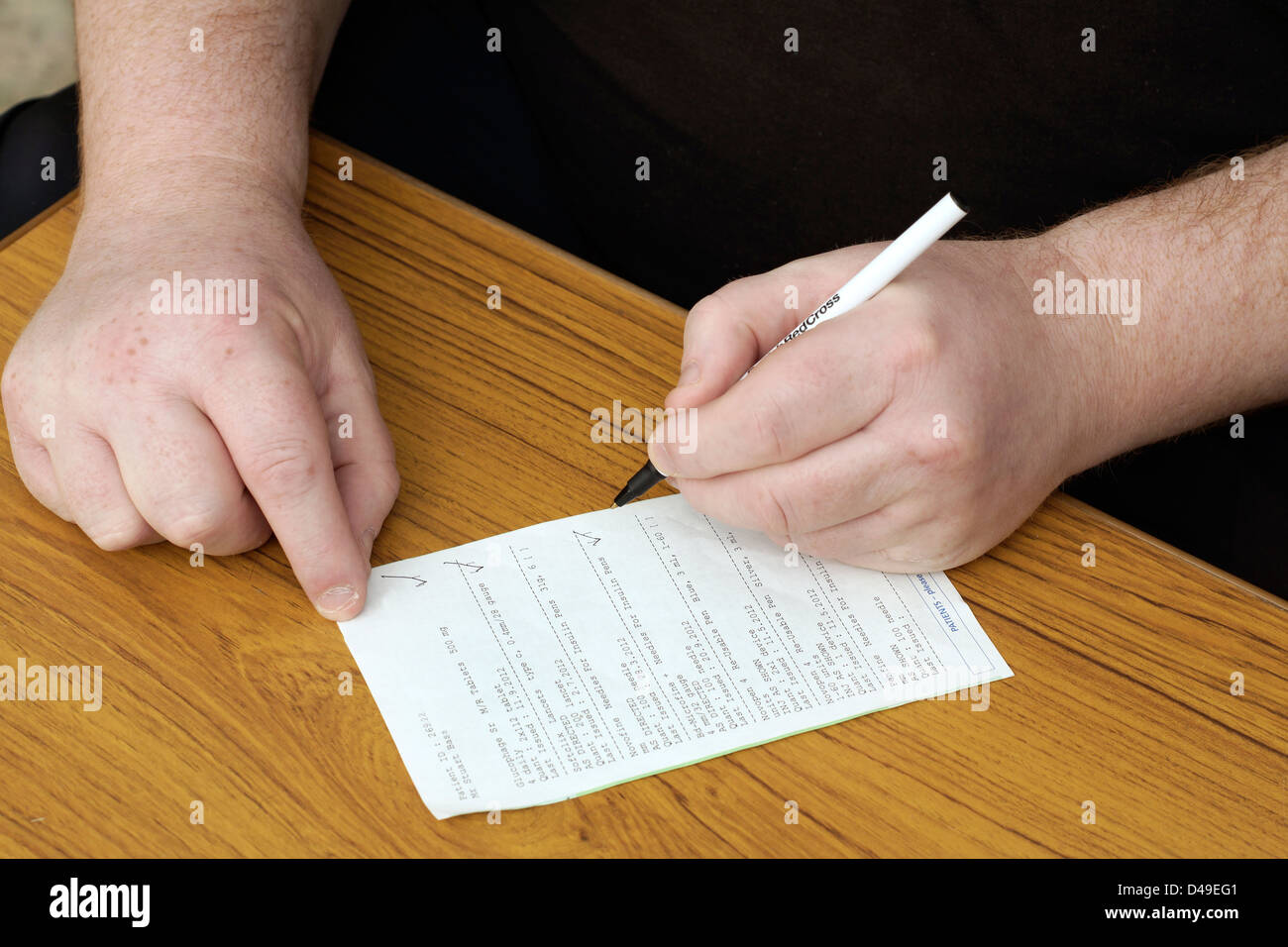 Man filling in form requesting repeat prescription / prescriptions ...