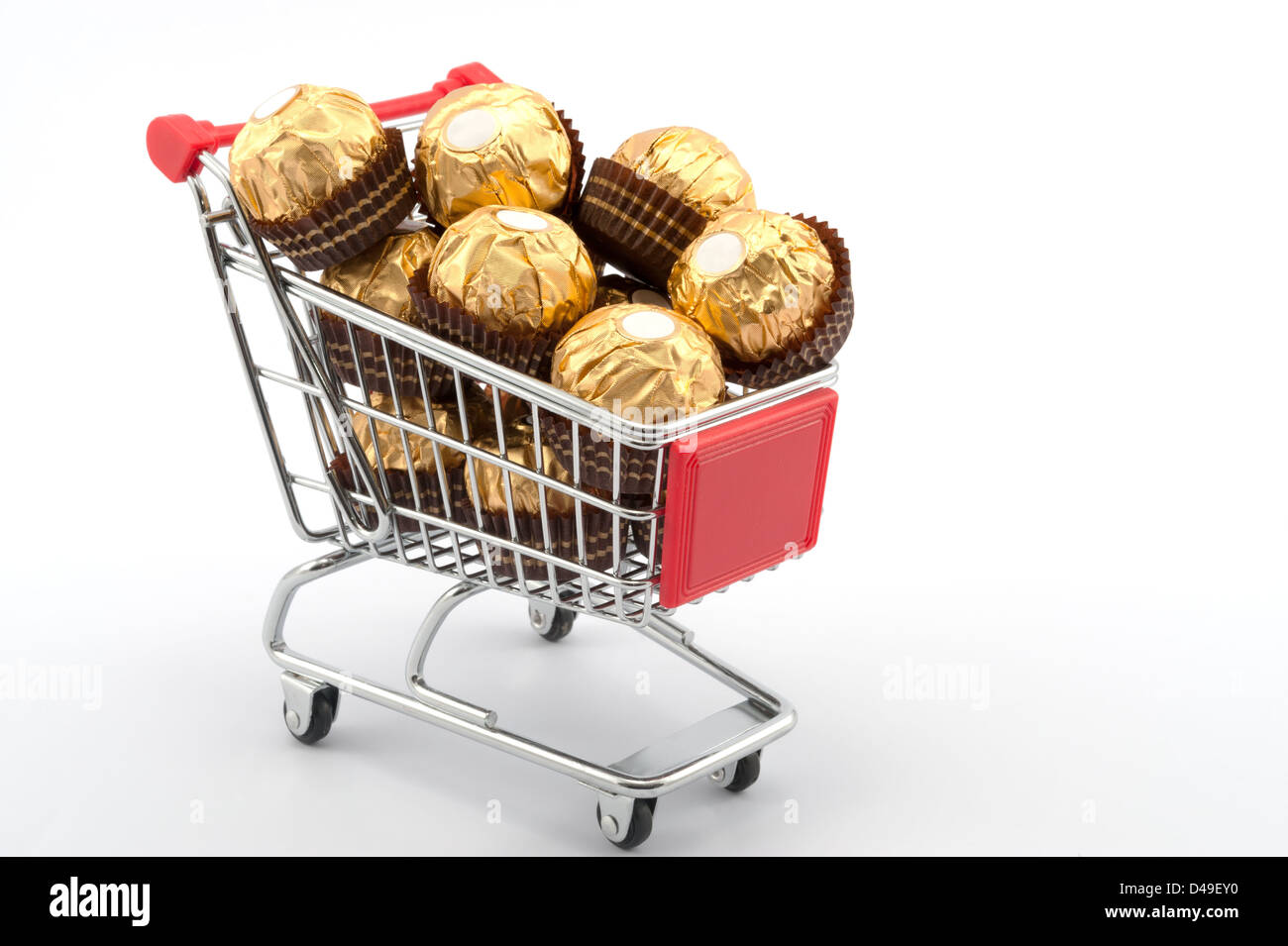 Shopping cart full of chocolates on white background Stock Photo - Alamy