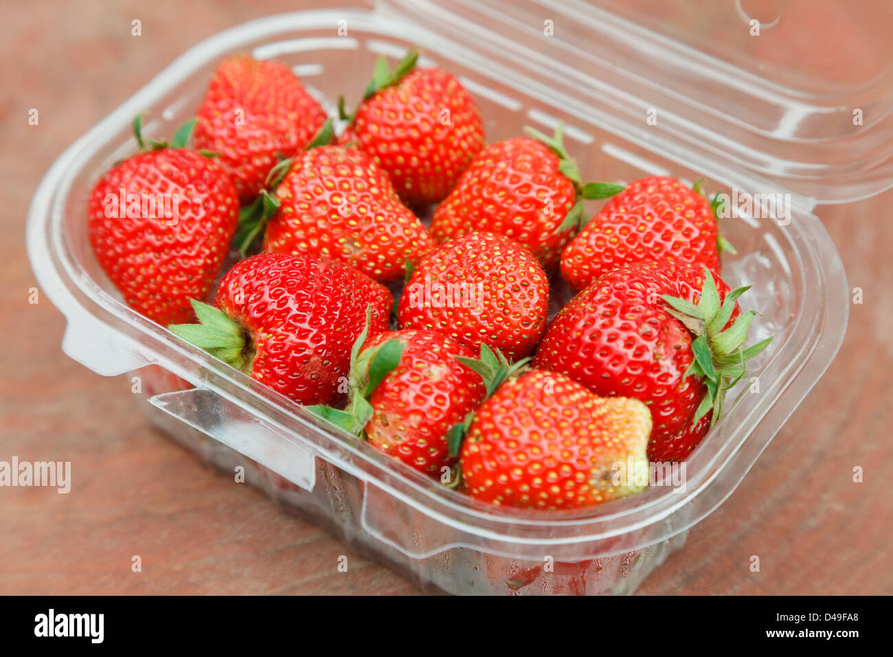Strawberry in plastic package on the wood table Stock Photo - Alamy