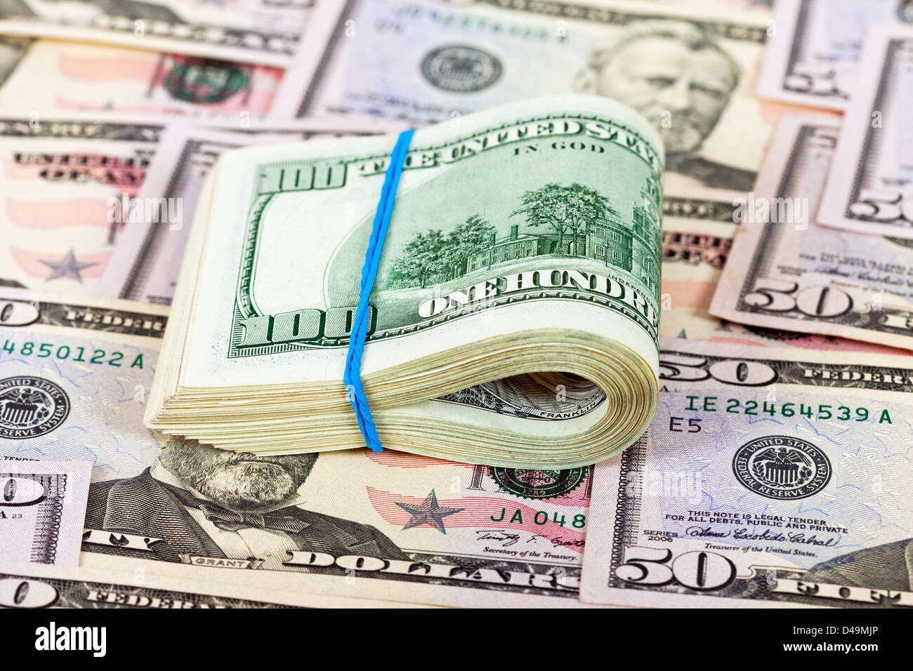 Folded dollar bills wrapped by rubber on money background Stock Photo ...