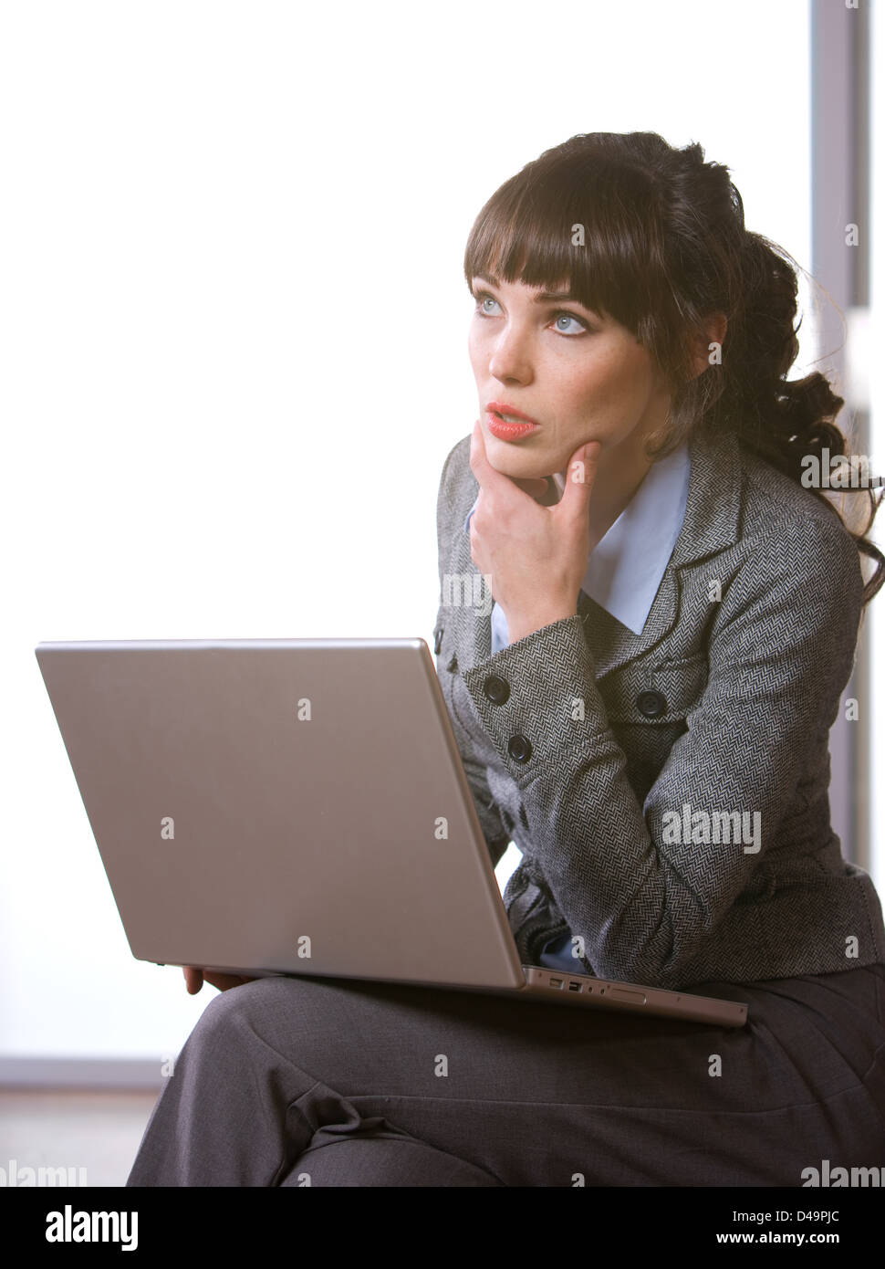 Business woman thinking in modern office with laptop Stock Photo - Alamy