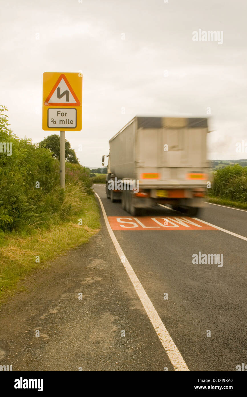 A HGV lorry on a country road traveling at speed around bends, with ...