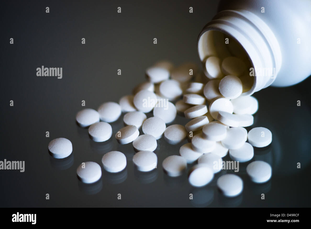 Aspirin tablets falling out of a jar Stock Photo - Alamy