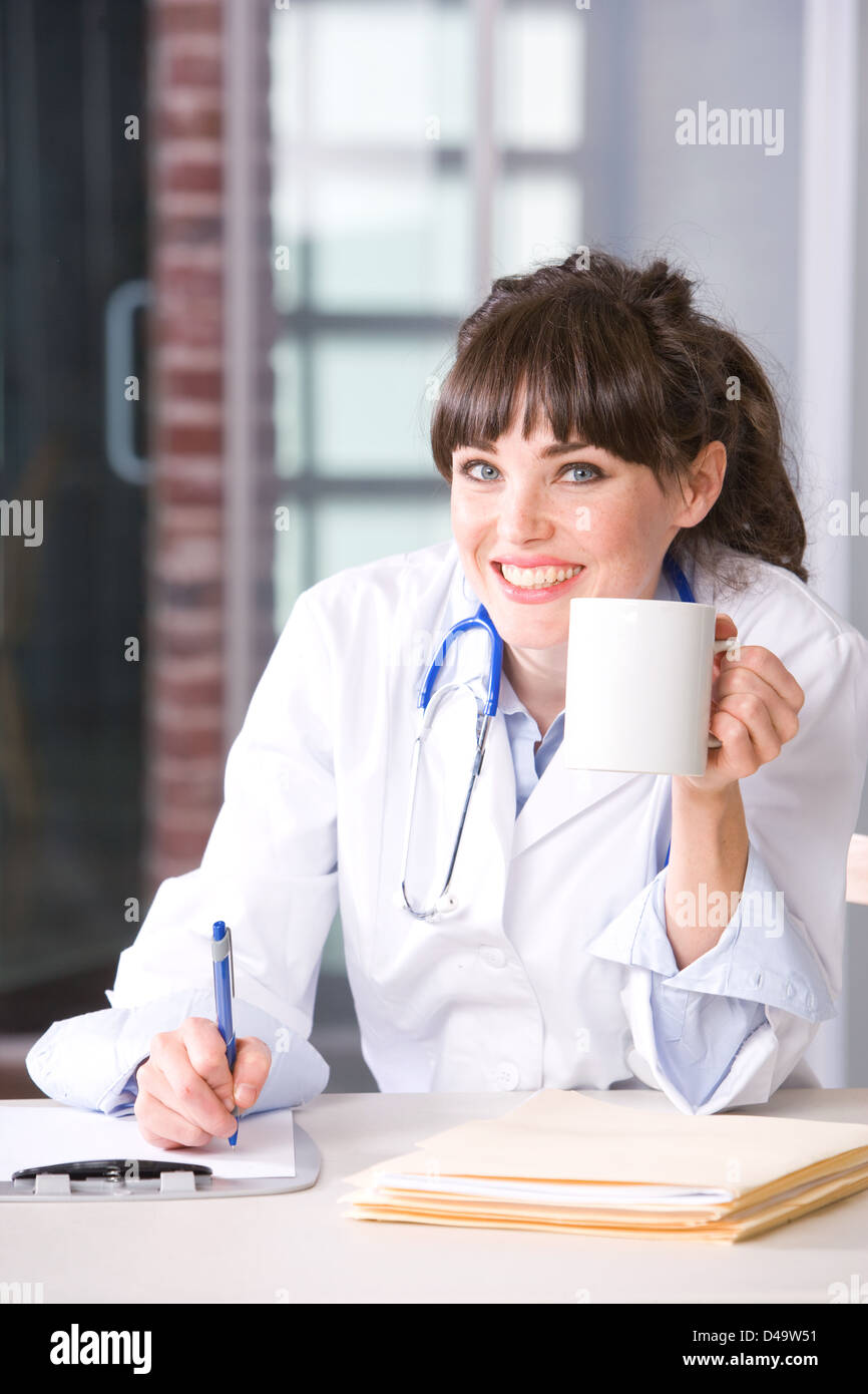 Female doctor in a modern office drinking coffee Stock Photo - Alamy