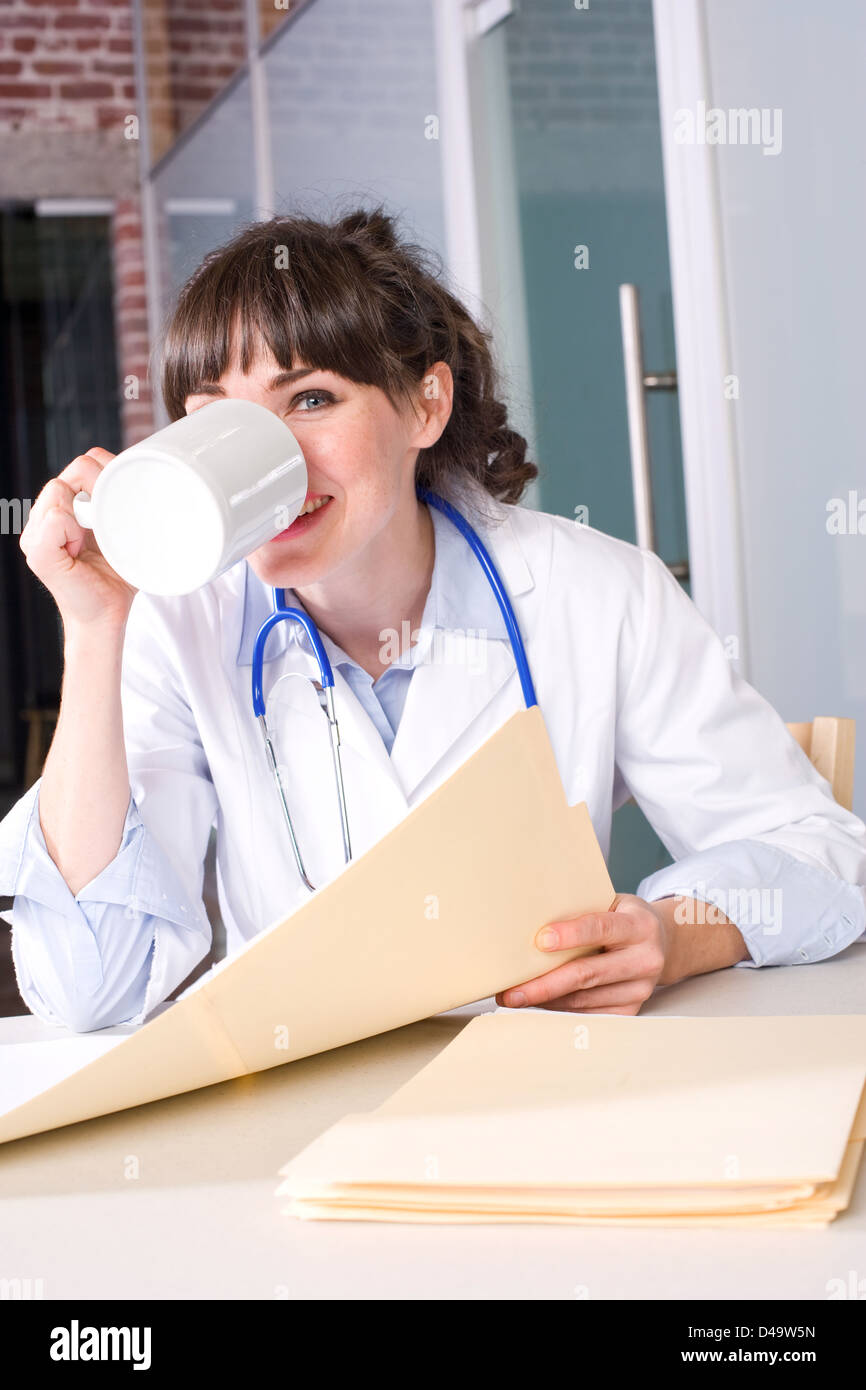 Female doctor in a modern office drinking coffee Stock Photo - Alamy