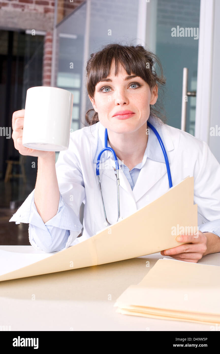 Female doctor in a modern office drinking coffee Stock Photo - Alamy