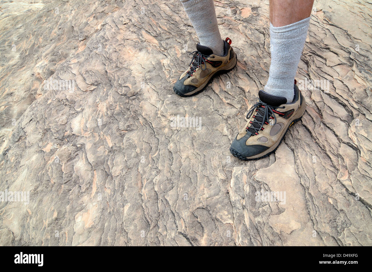 Hiker's legs and feet on sandstone rock in the desert of Southern Utah ...