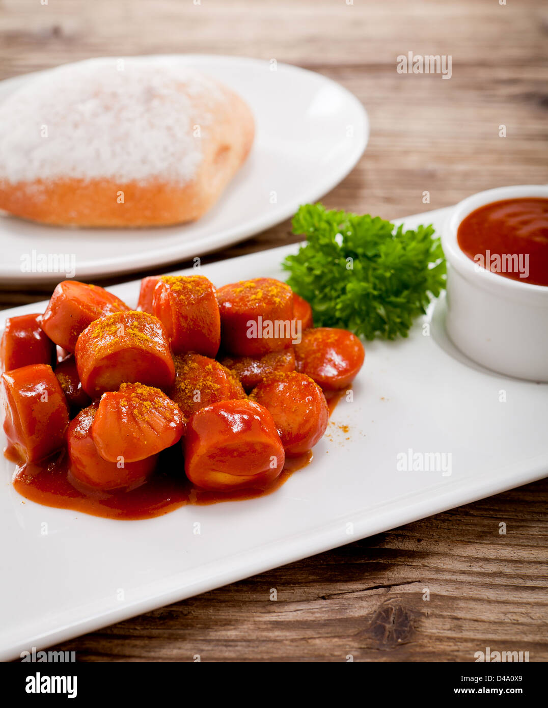 curry wurst spicy sausage with curry and ketchup on wooden background ...