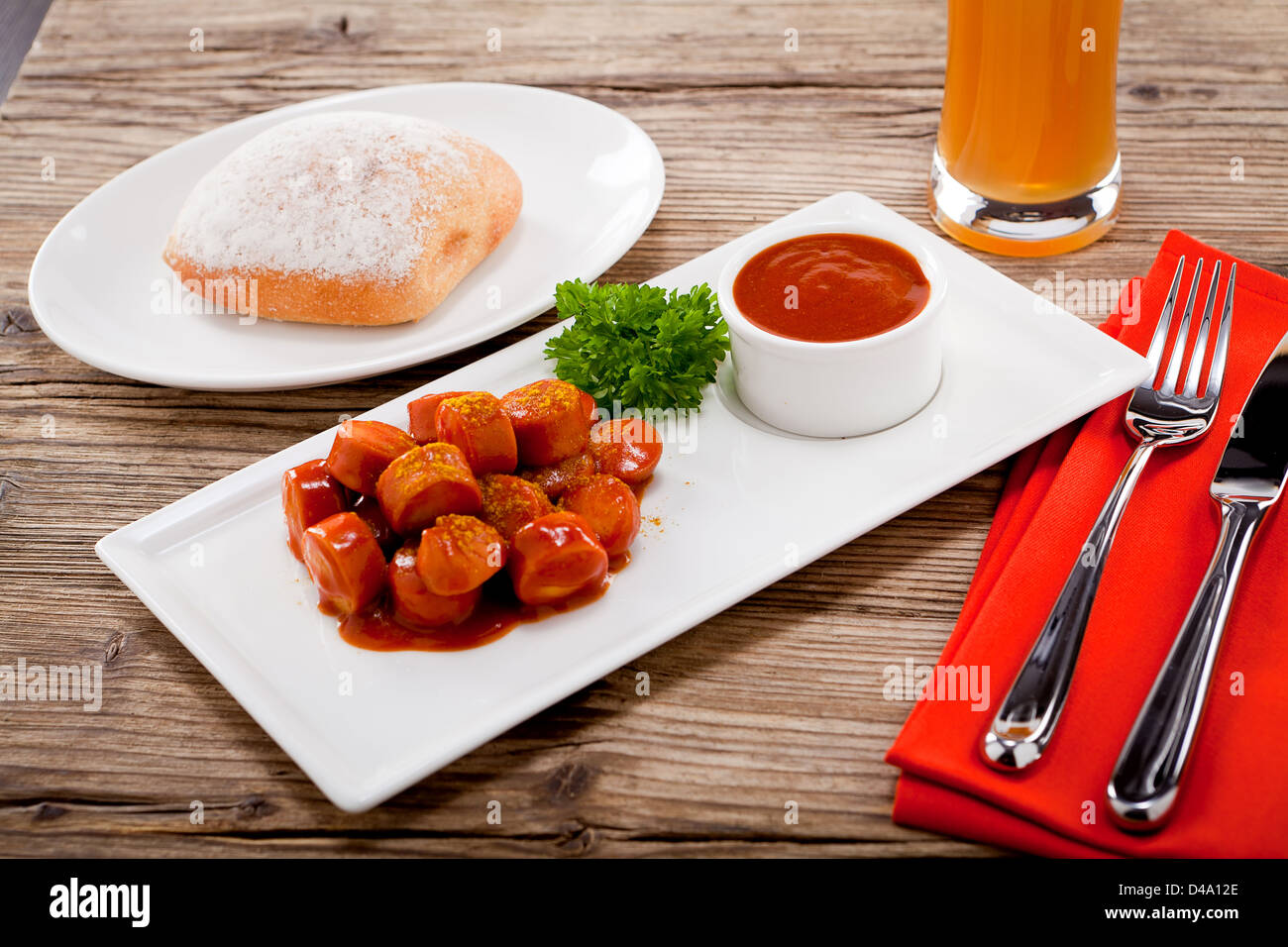 curry wurst spicy sausage with curry and ketchup on wooden background ...