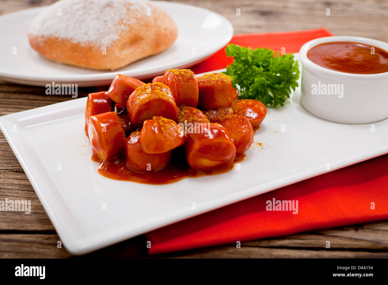 curry wurst spicy sausage with curry and ketchup on wooden background ...