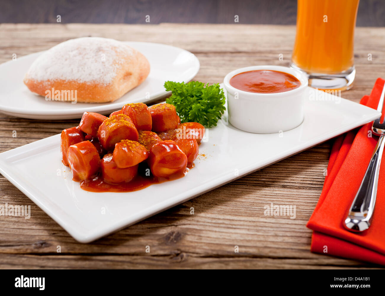 curry wurst spicy sausage with curry and ketchup on wooden background ...