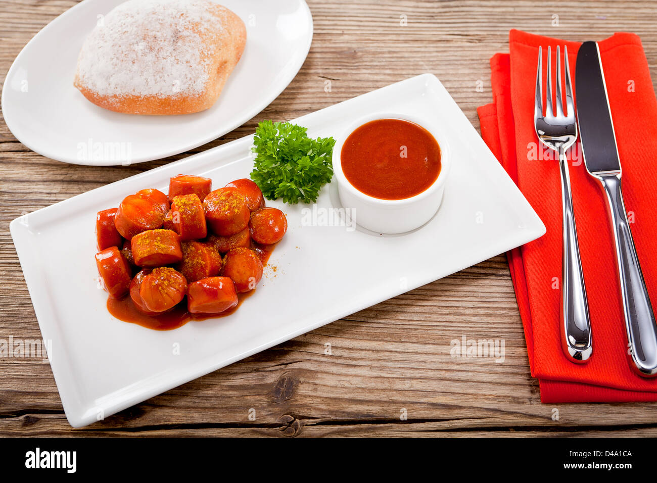 curry wurst spicy sausage with curry and ketchup on wooden background ...