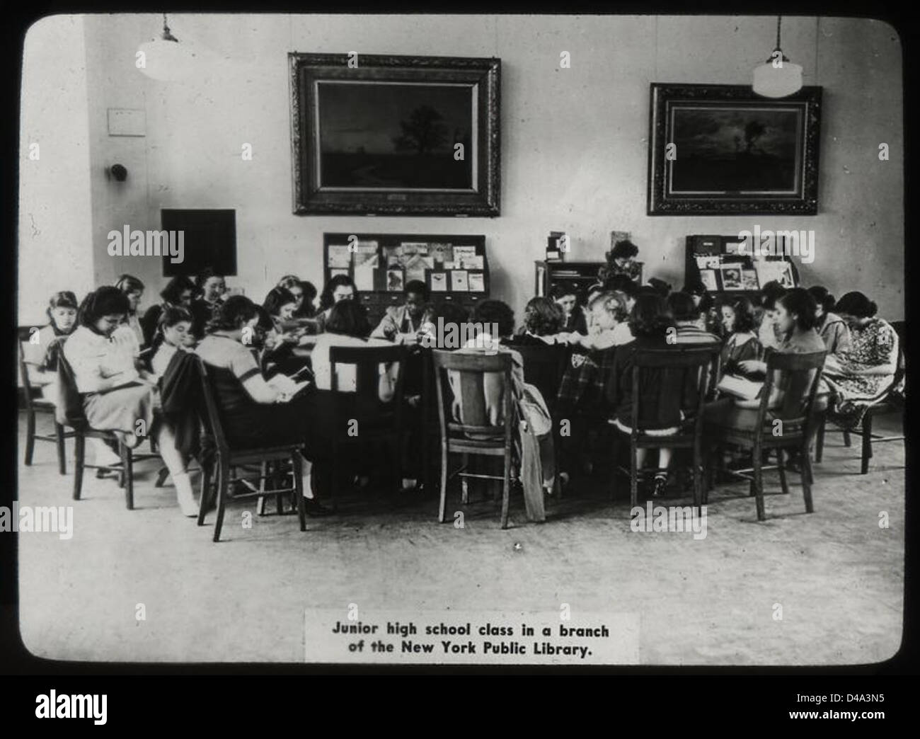 This photograph from 1938 shows a junior high school class in a library ...