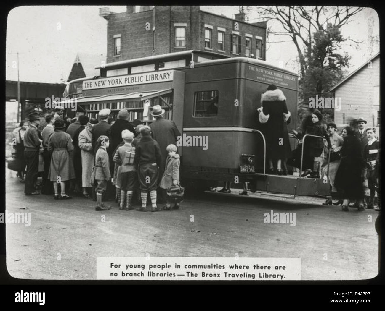 The image captures people using the Bronx Traveling Library, a mobile ...