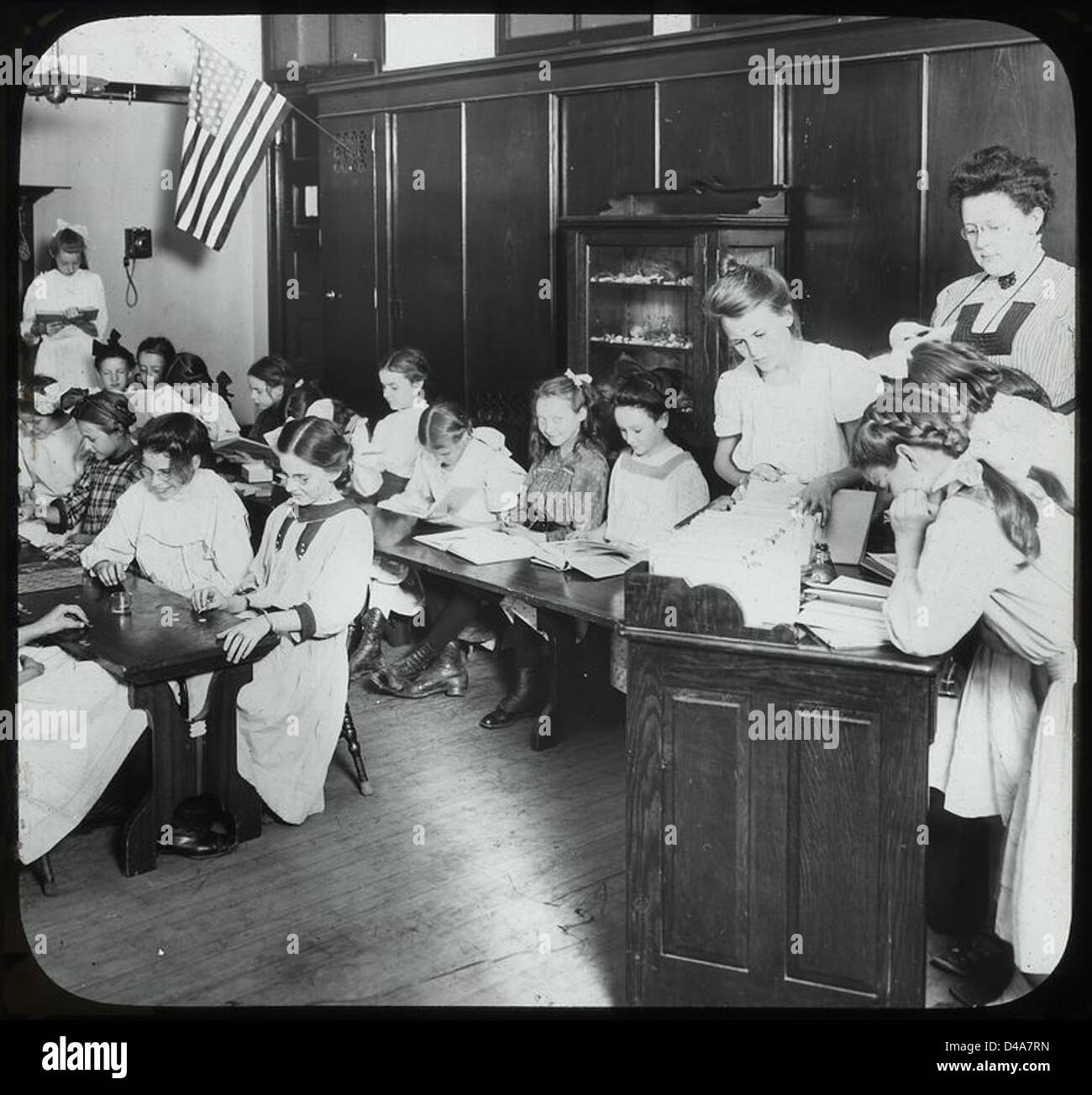 This 1910 image shows a group of girls in a classroom, part of the ...