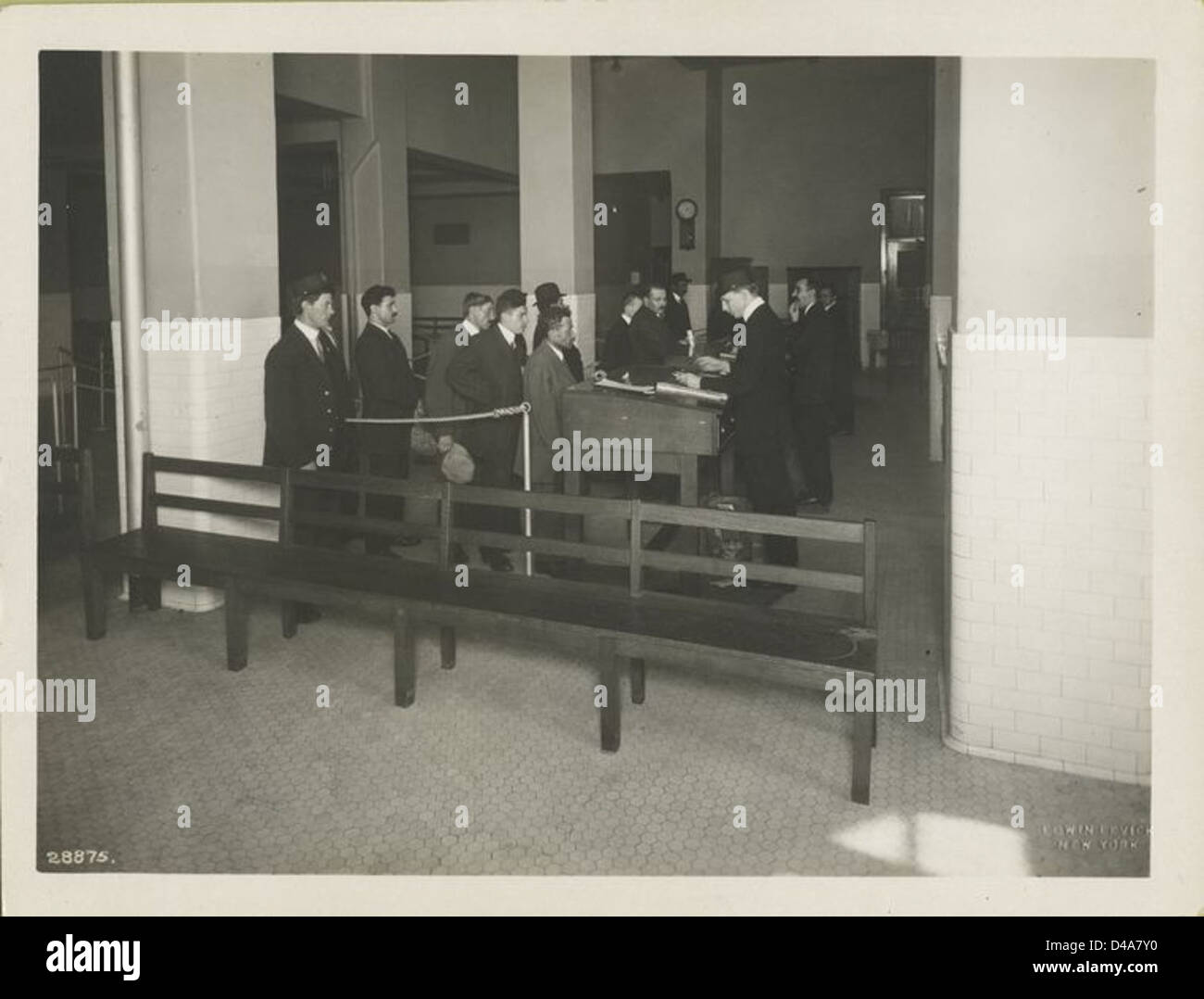 A photograph from 1910 showing immigrants waiting in line for ...