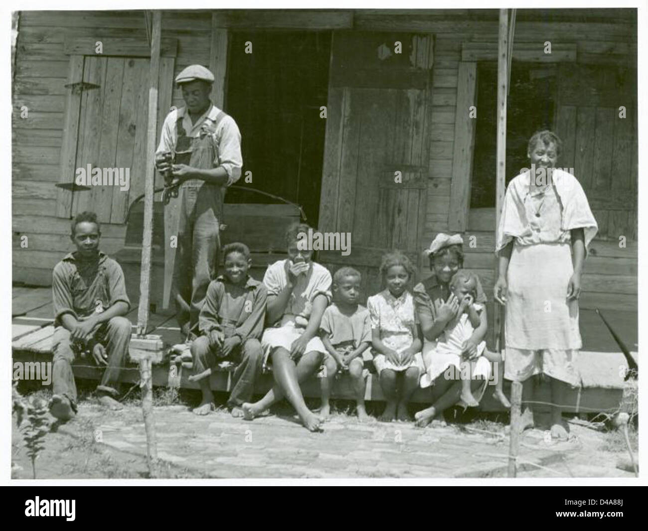 This 1940 photograph shows African American men, women, and children at ...