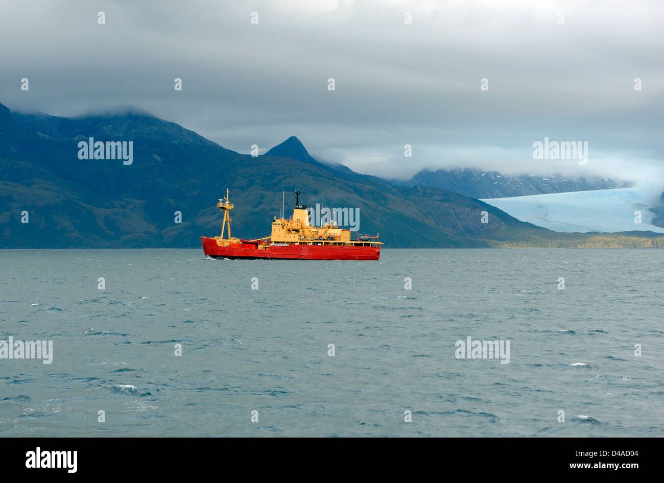 A red and yellow ship with two helicopters in typical gloomy weather in ...