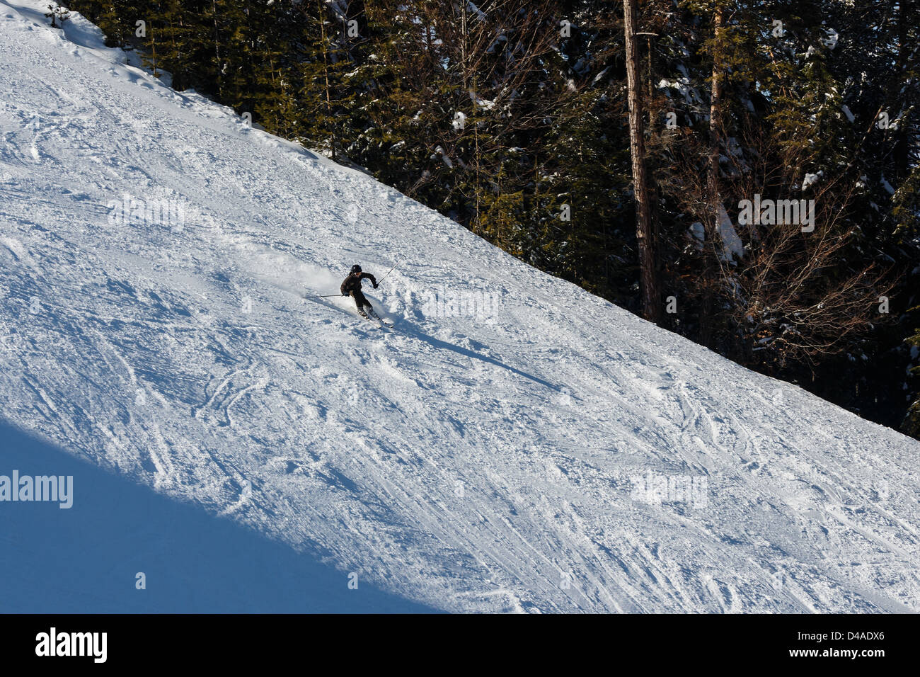 Mountain skier going down from a mountain slope Stock Photo - Alamy