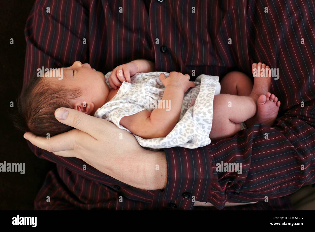 A close up of a newborn baby being held by a man's hand Stock Photo - Alamy