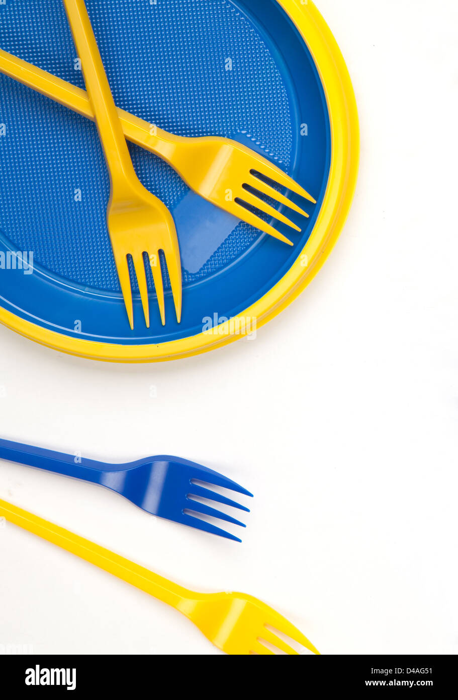 bright blue and yellow plastic disposable tableware, plates and forks ...