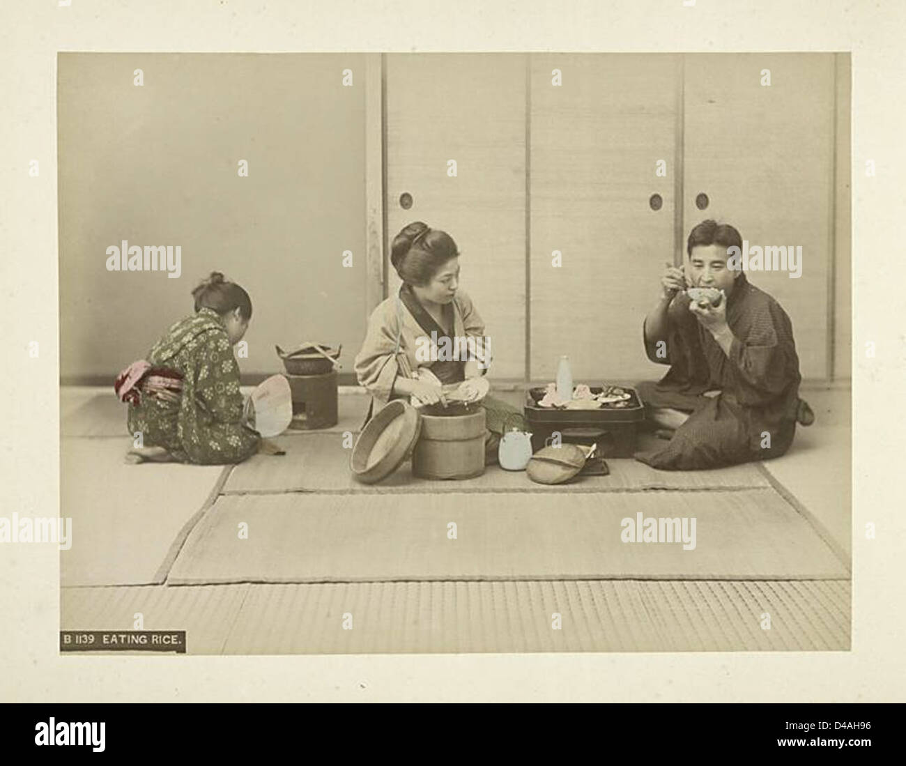 A traditional Japanese scene depicting people eating rice, reflecting ...