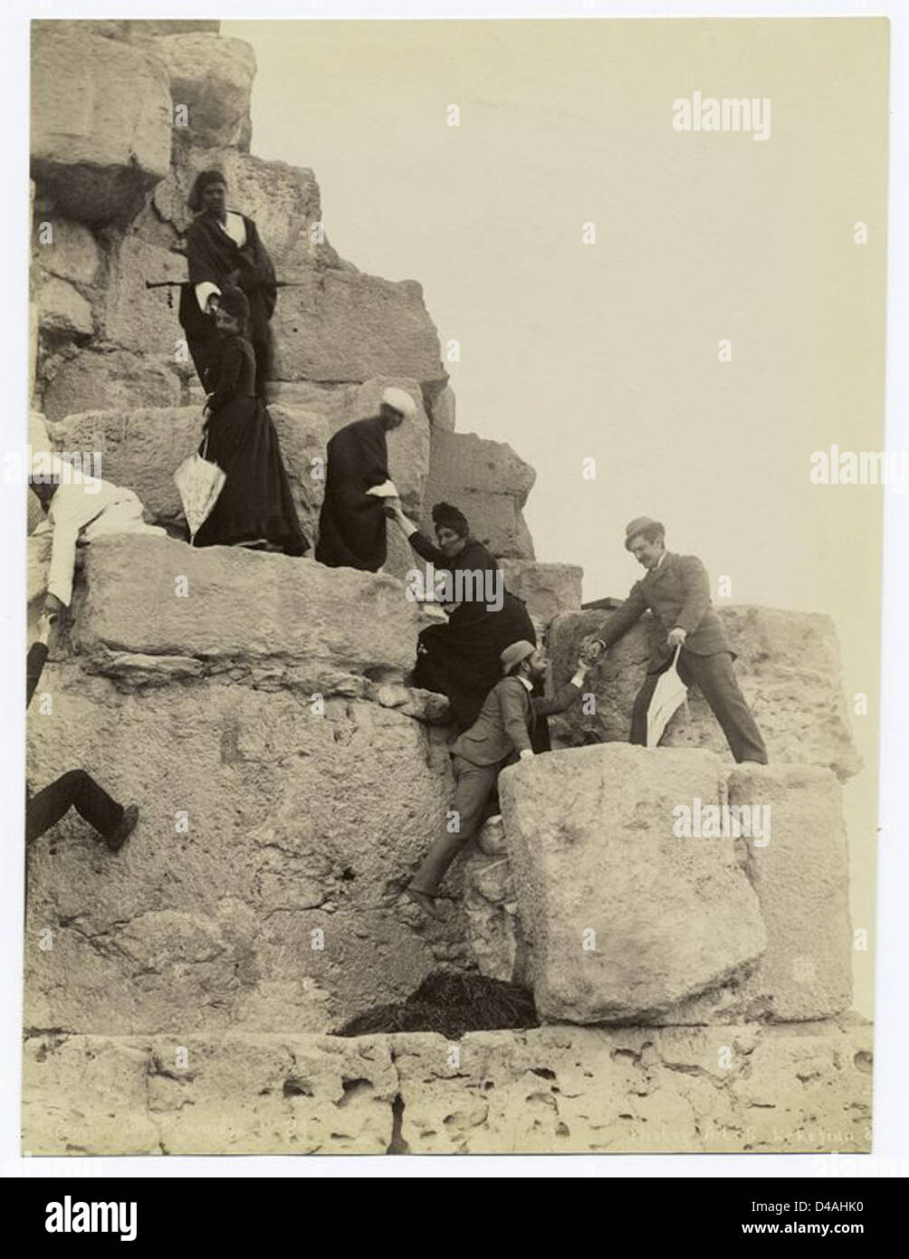 This 1860 photograph depicts tourists climbing the pyramids of Egypt ...